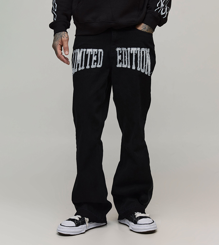 Buy BoohooMAN Tall Raw Hem Applique Gusset Flared Jeans In Black ...