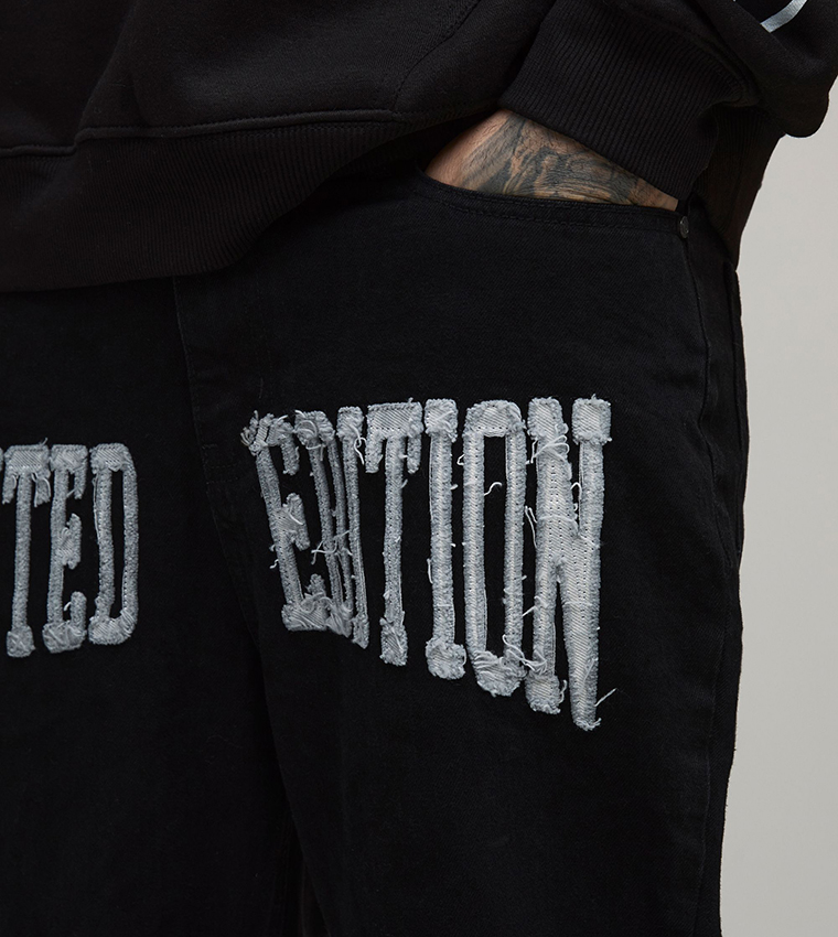 Buy BoohooMAN Tall Raw Hem Applique Gusset Flared Jeans In Black ...